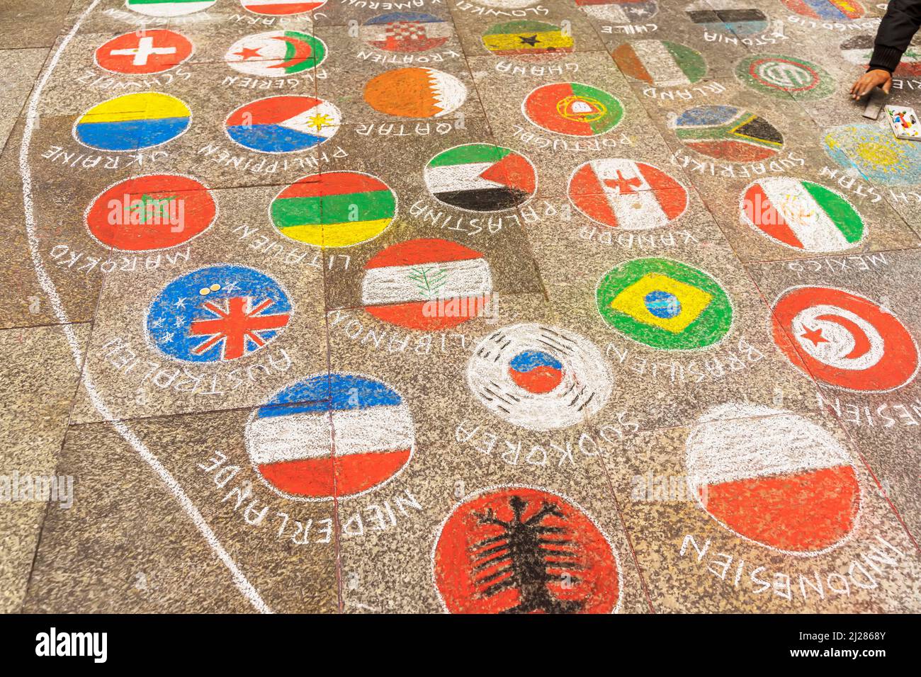 Hand of teenager drawing multi-colored flags of different countries in ...