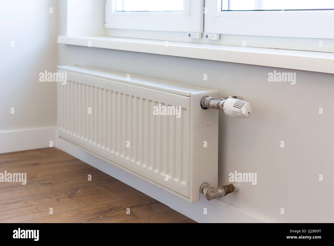Wall mounted heating radiator with thermostat. Battery Stock Photo - Alamy