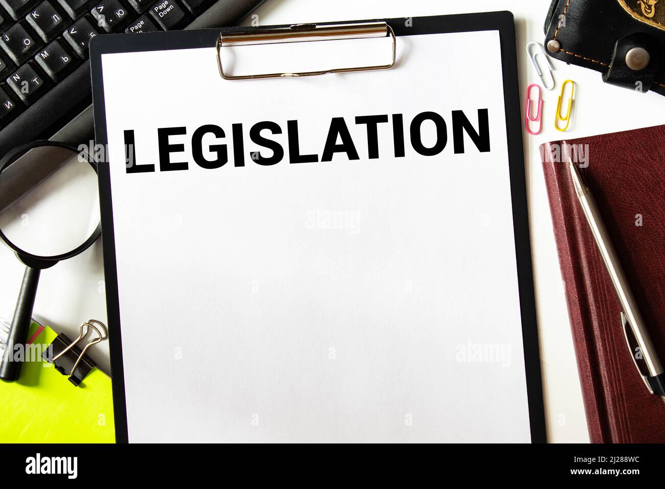 Laptop, red pen and notepad with text LEGISLATION in the white ...