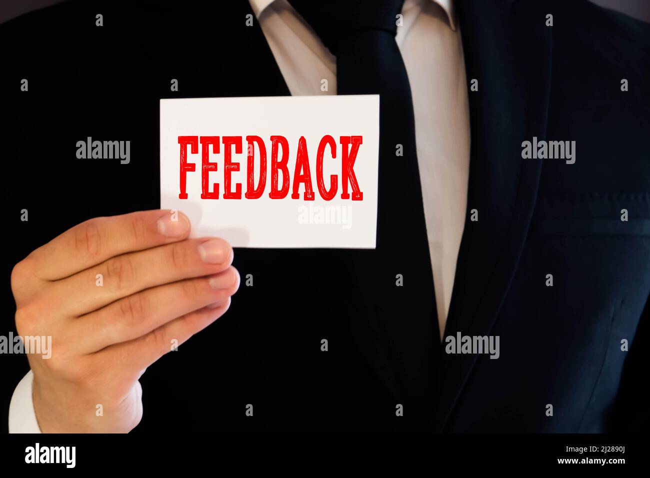 FEEDBACK word on the card shown by a man, vintage tone Stock Photo - Alamy