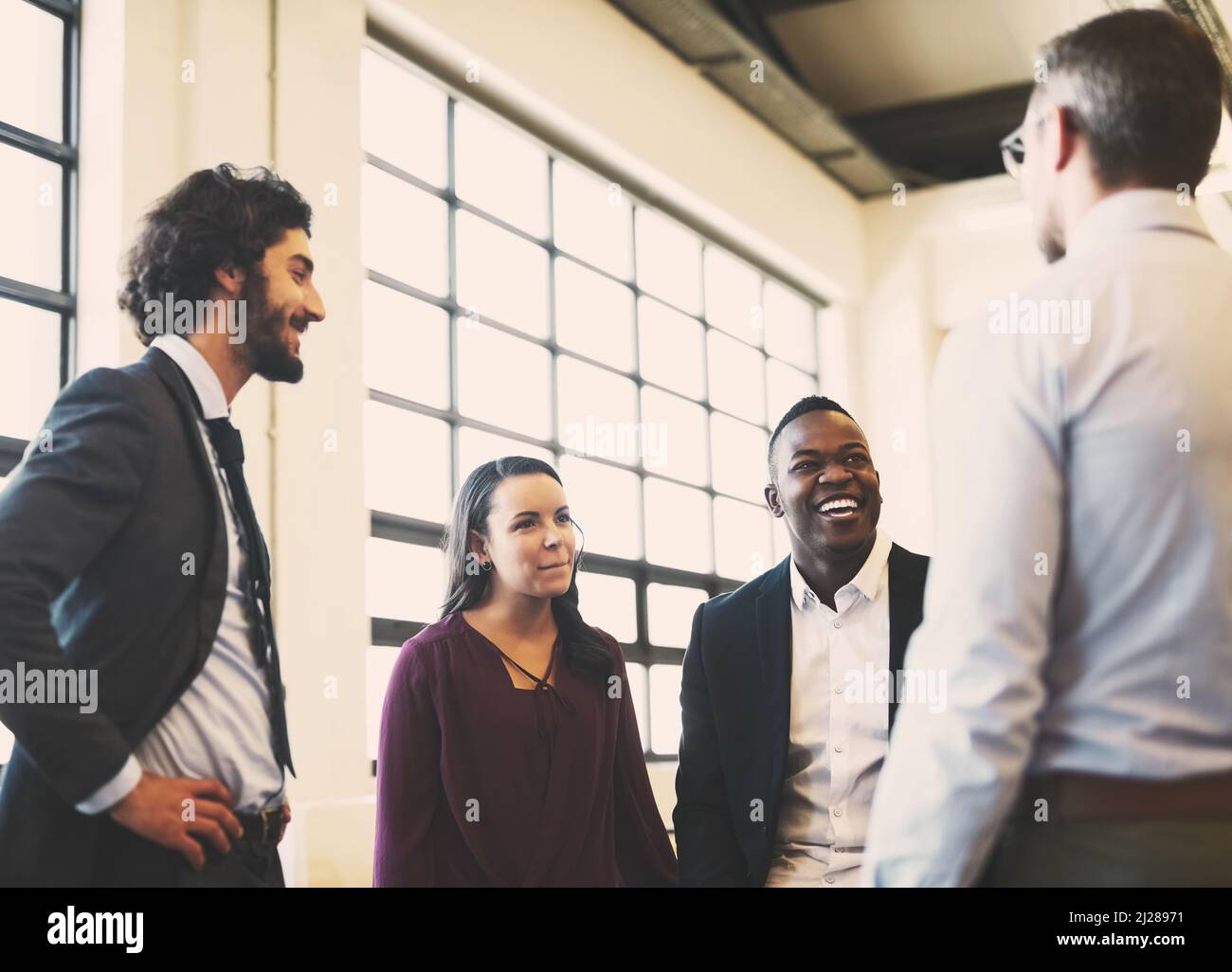 Catching up with the team. Shot of a team of laid-back businesspeople ...