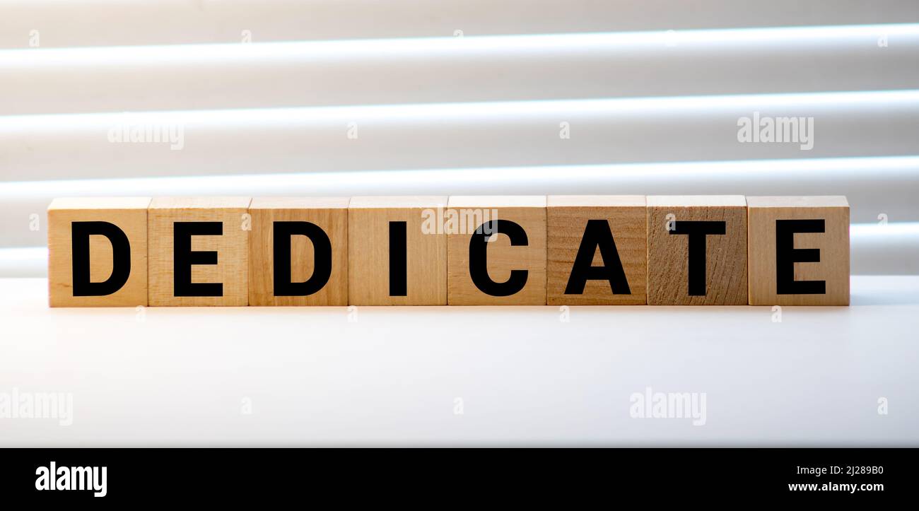 Word Dedicate on a row of wooden blocks. Devotion dedication love concept Stock Photo - Alamy
