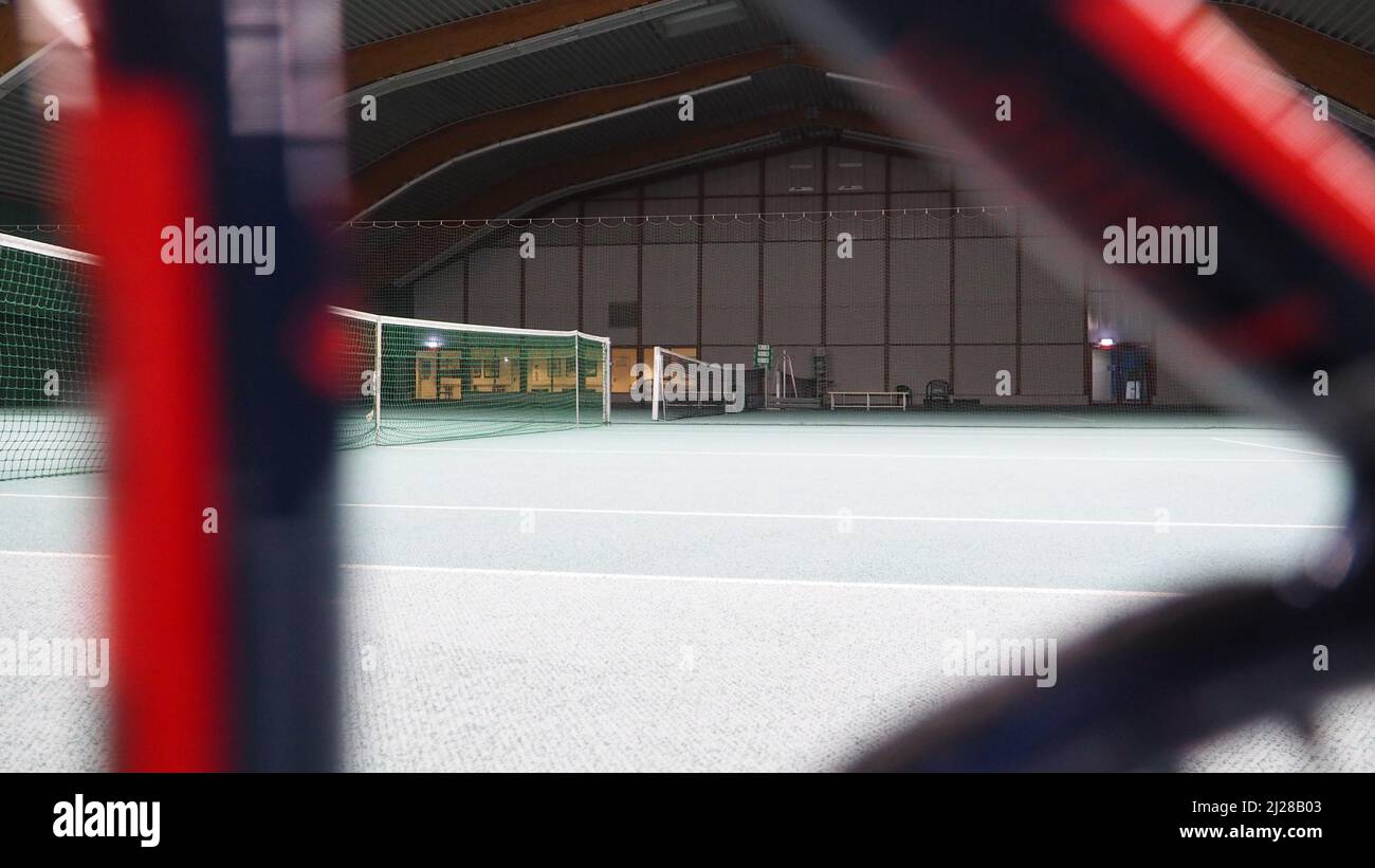 A view of an indoor tennis court taken from a hole in the tennis racket ...