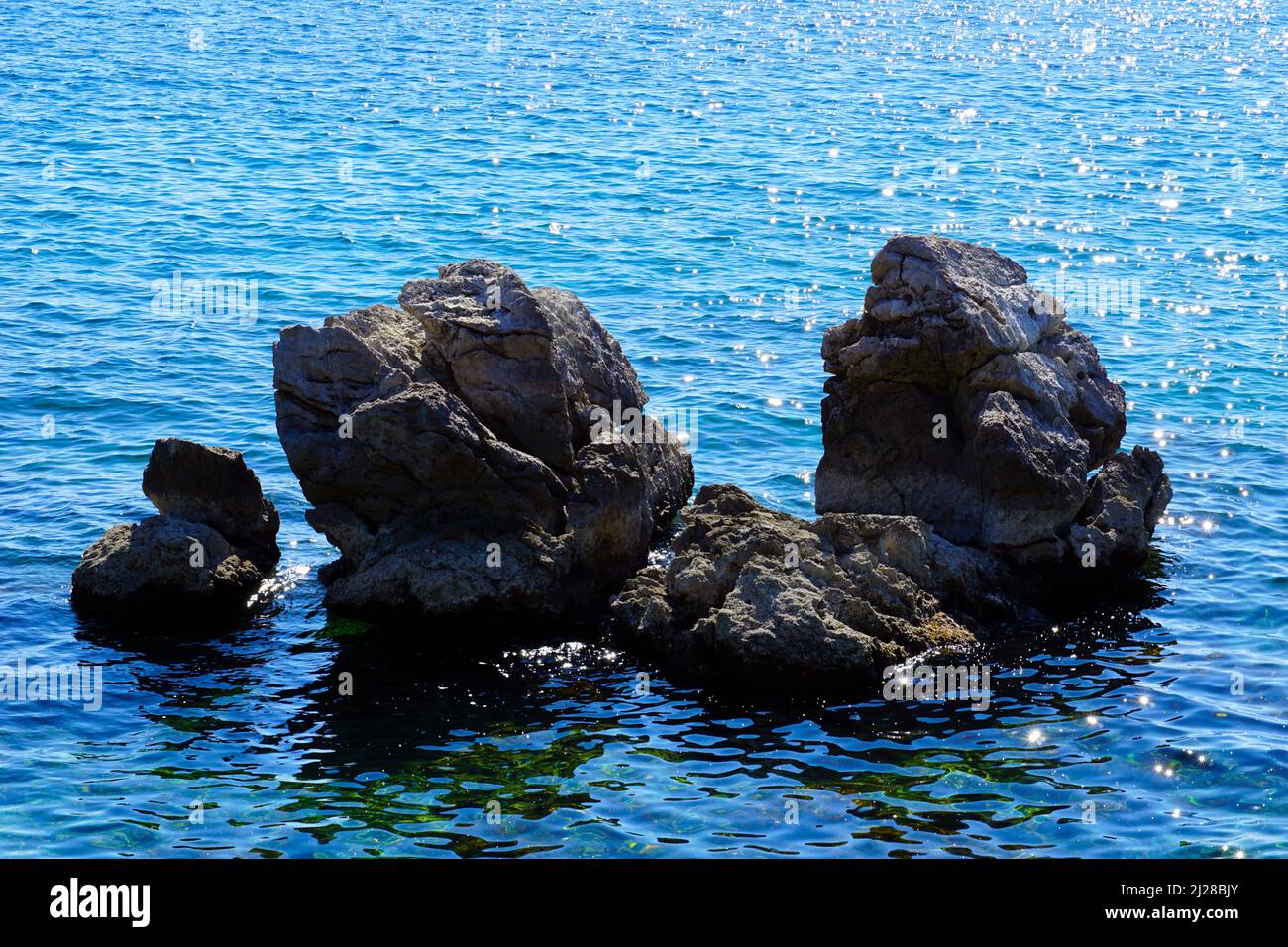 Huge rocks from the seabed rise above the surface of the seawater Stock ...