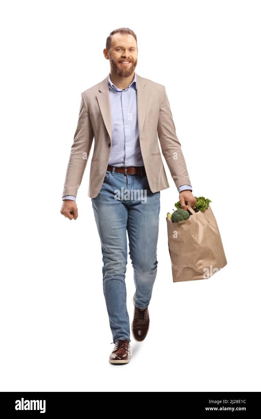 Full length portrait of a young man carrying a paper bag with groceries ...