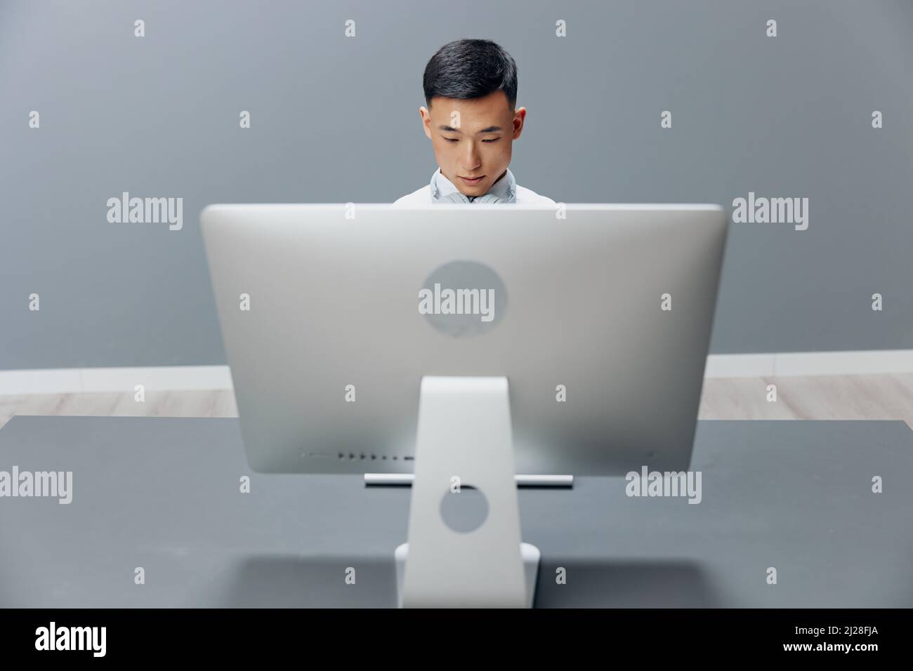 manager working in front of computer sitting at a table in the office ...