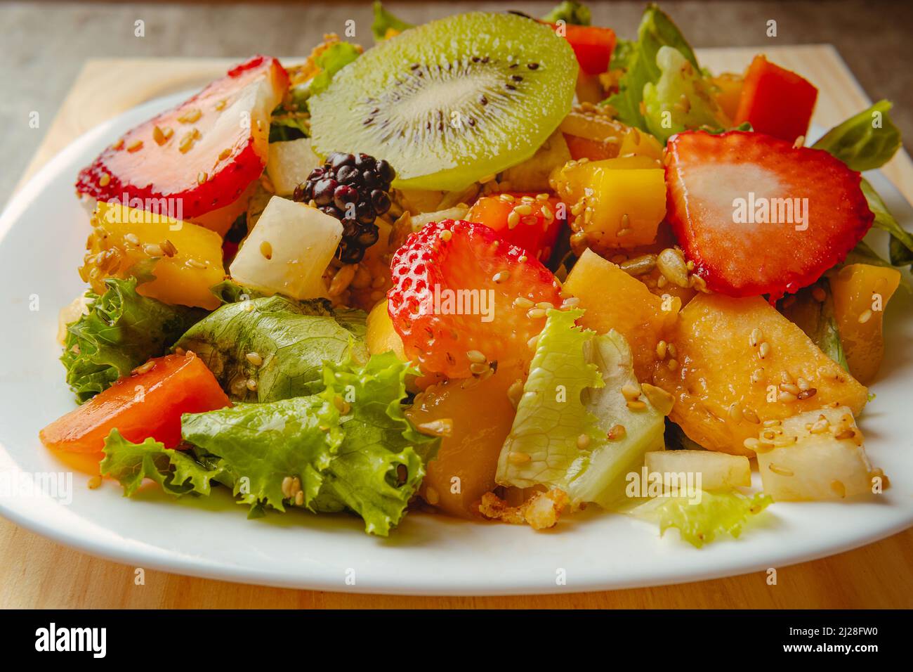 Healthy fresh fruit salad with fried chicken on a wooden background ...