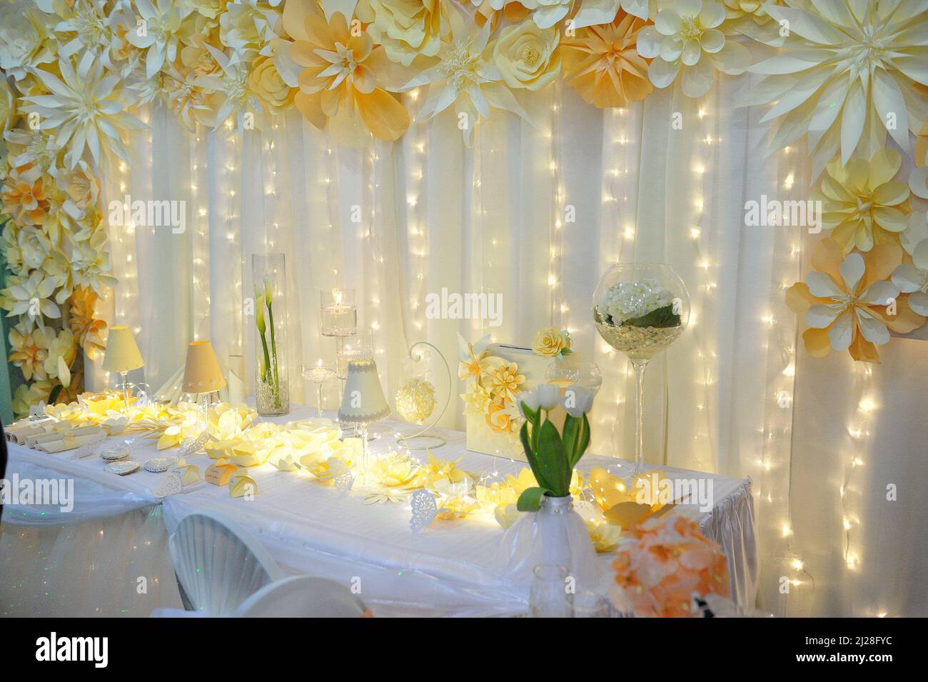 A decorated table and curtains with flowers and lights for an event ...