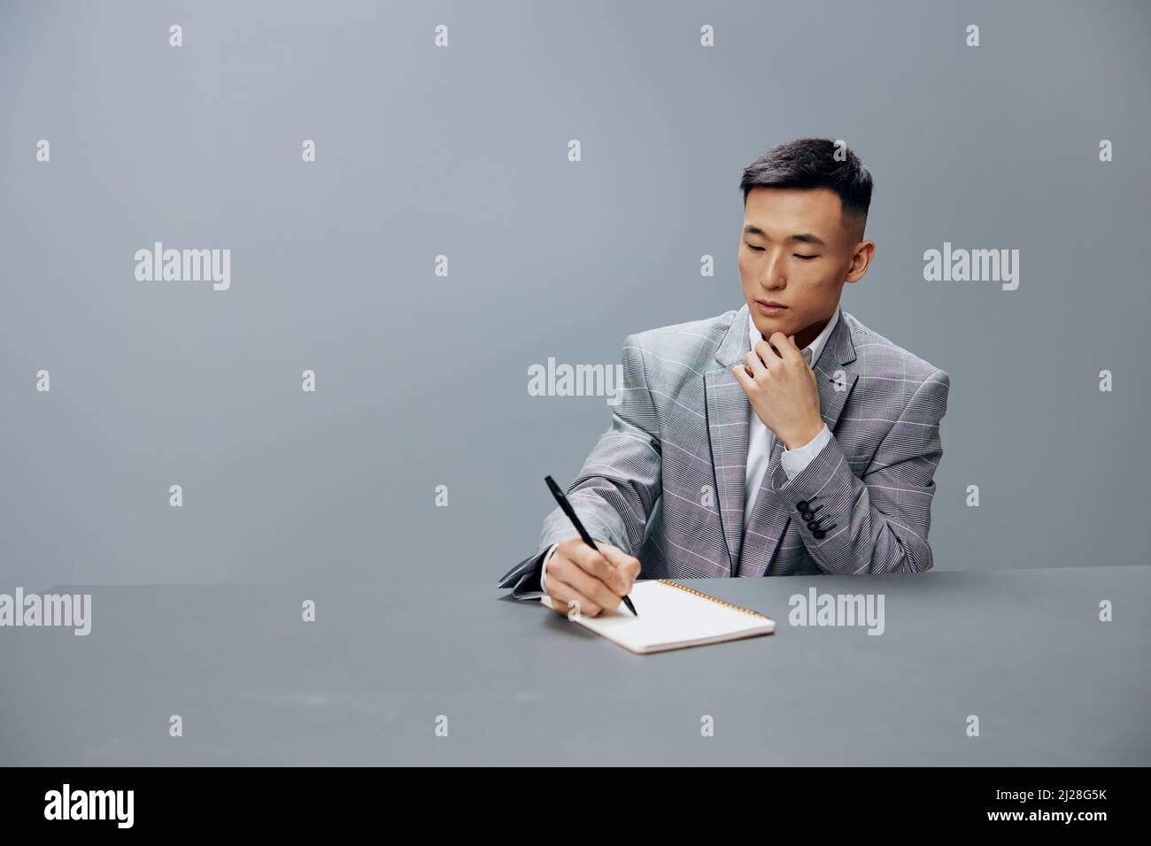 man in a gray suit in the office with a notepad on the table the idea ...