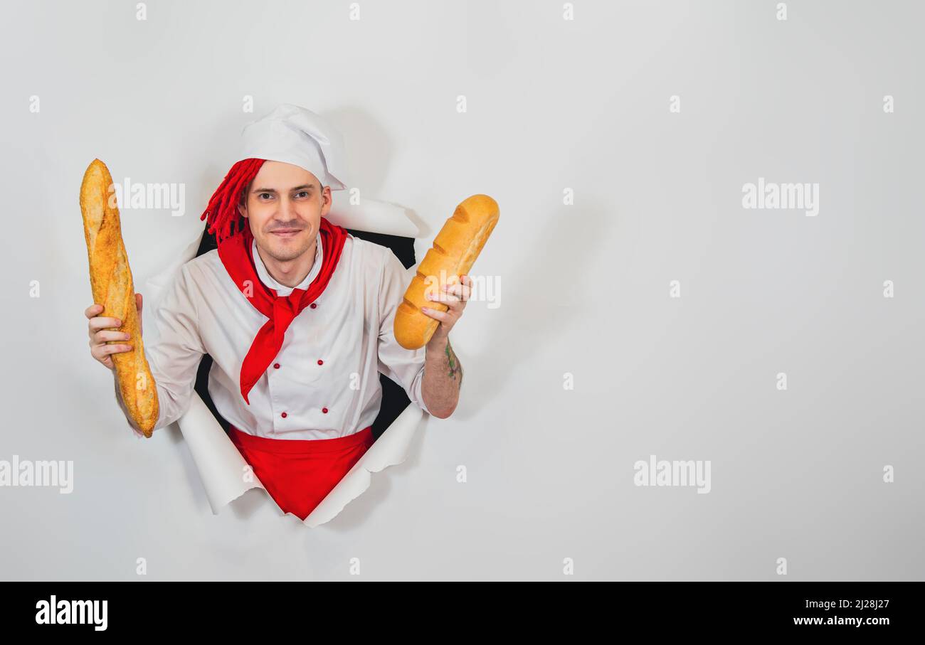 Young man with red dreadlocks dressed as chef holding white bread. Male ...
