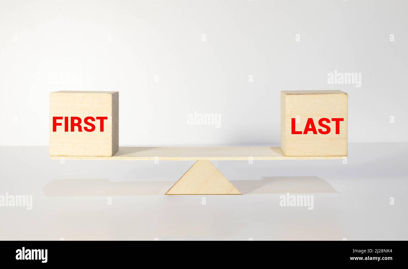 Wooden signpost with two opposite arrows over green leaves background ...