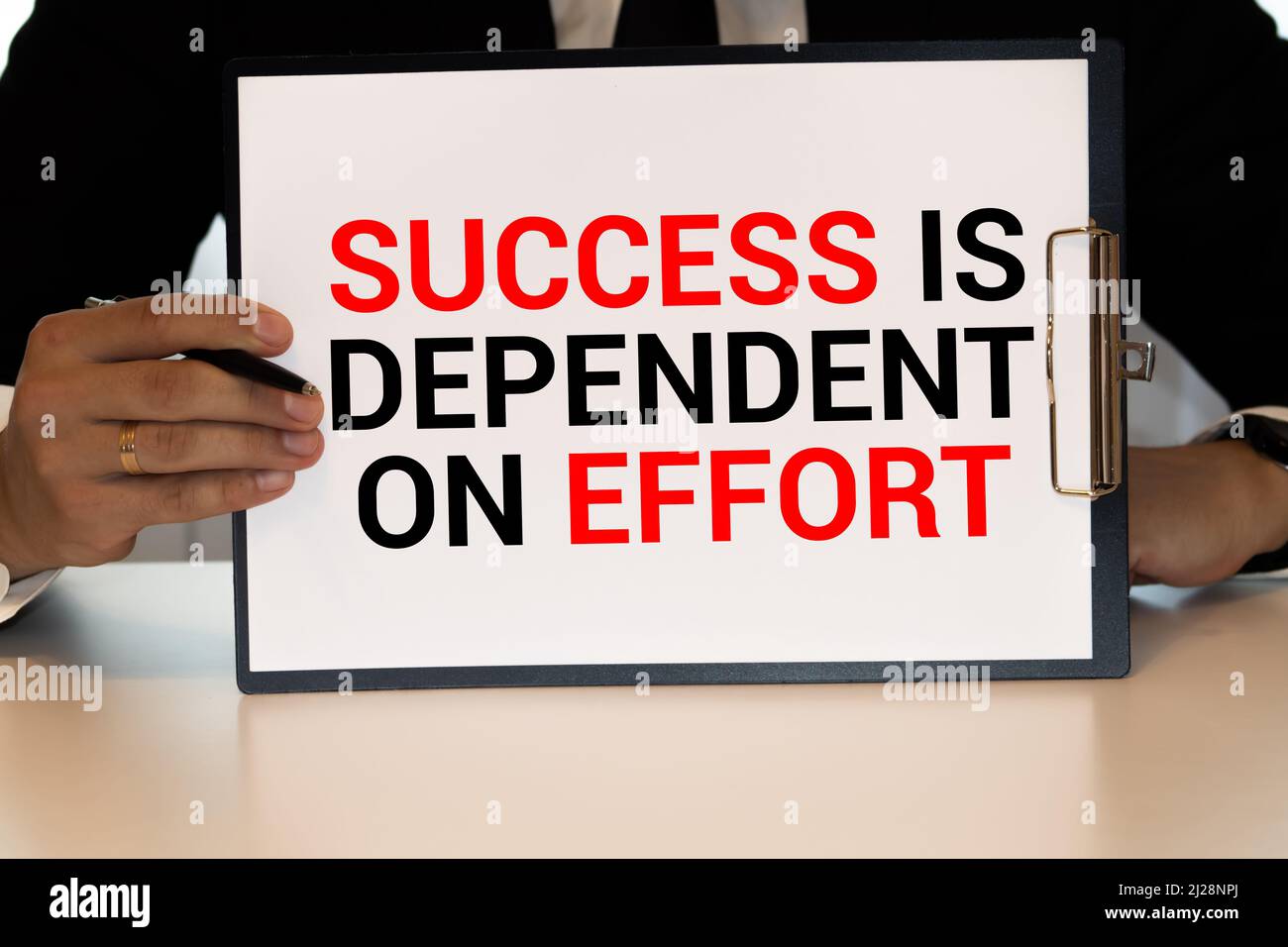 Text Success is dependent on effort on white background Stock Photo - Alamy