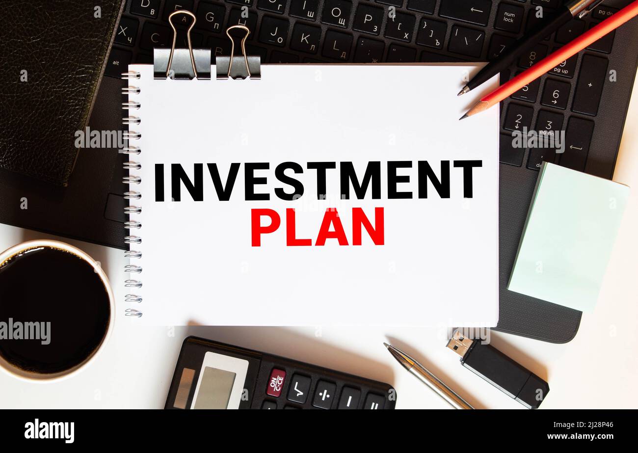 Office desk table with notebook written INVESTMENT PLAN with laptop ...
