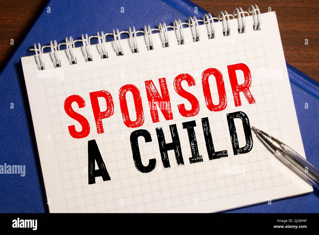 Sponsor A Child text written on a notebook with pencils Stock Photo - Alamy