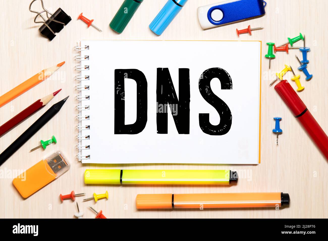 DNS, Domain Name System, text on white card next to notepad and pen on ...