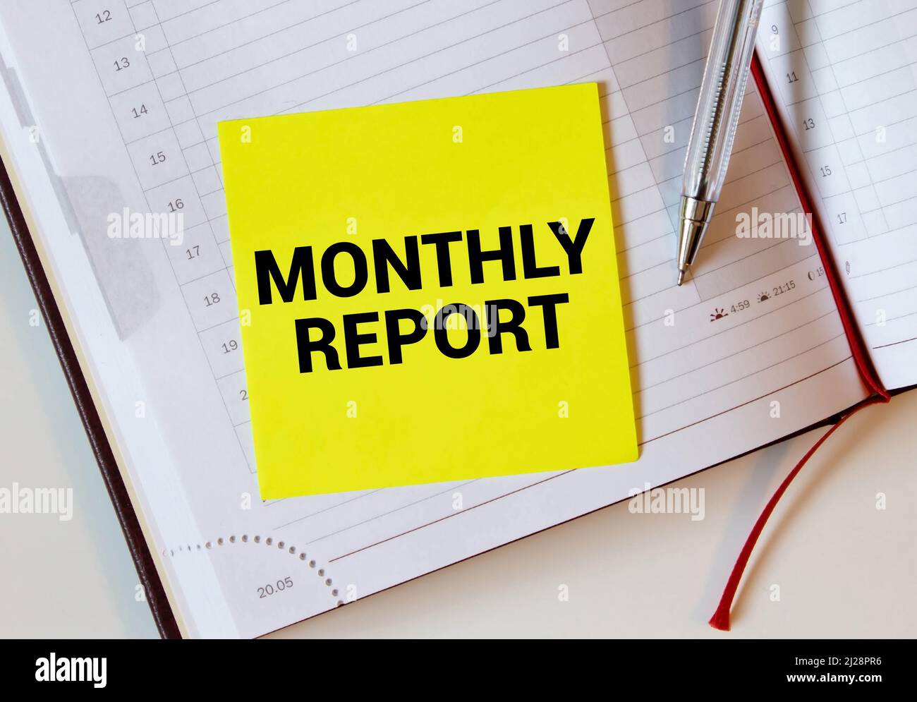 Text Monthly Report on yellow stickers with calculator, blue pen and ...