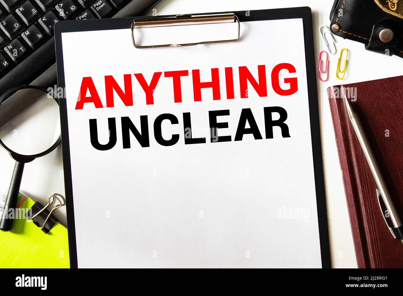 Laptop, red pen and notepad with text ANYTHING UNCLEAR in the white ...