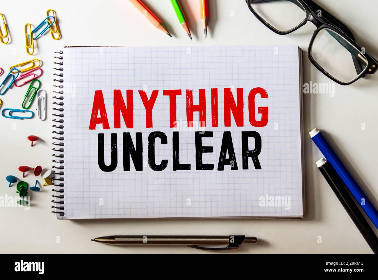 ANYTHING UNCLEAR text on paper sheet with chart, dice, spectacles, pen ...