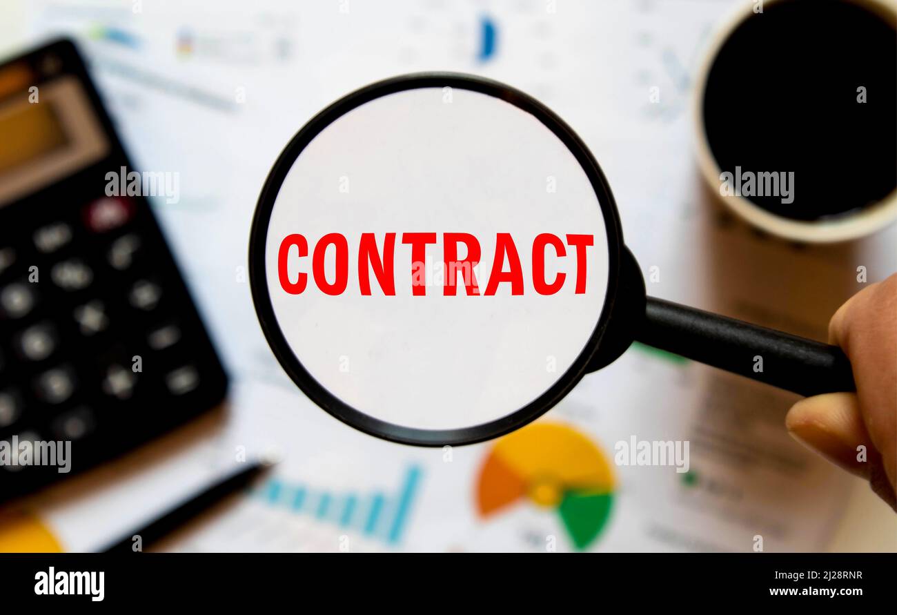 Magnifying glass over contract document, highlighting the word contract ...