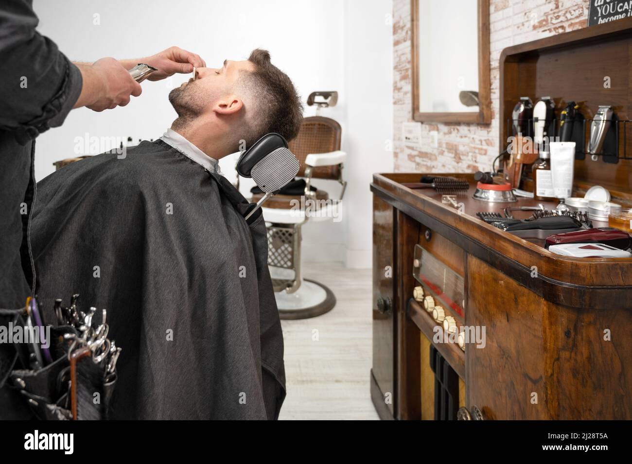 Professional barber cutting beard of handsome man. High quality ...