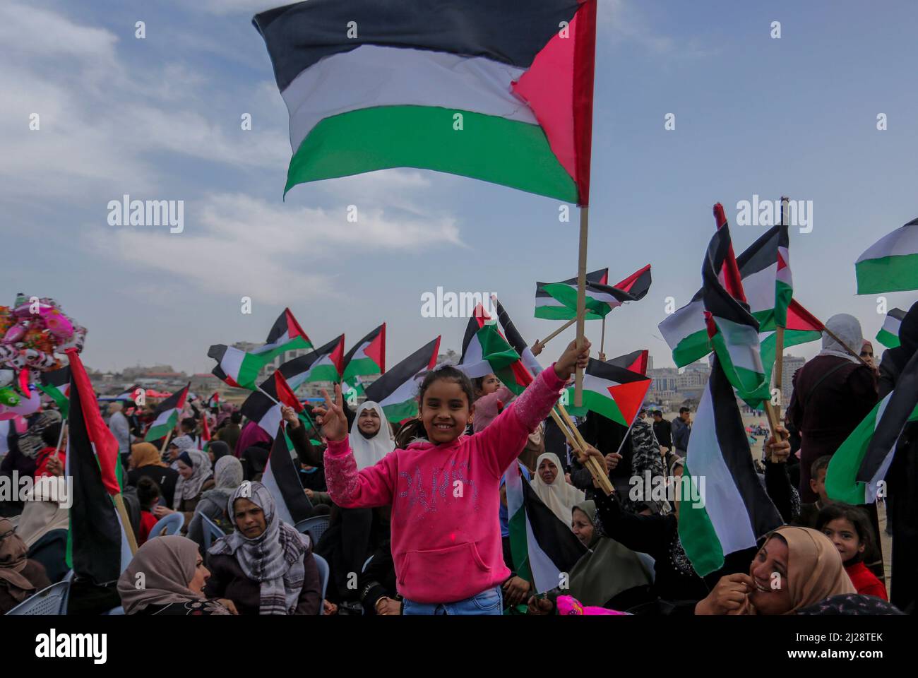 Gaza, Palestine. 30th Mar, 2022. A Palestinian girl waves a flag while ...