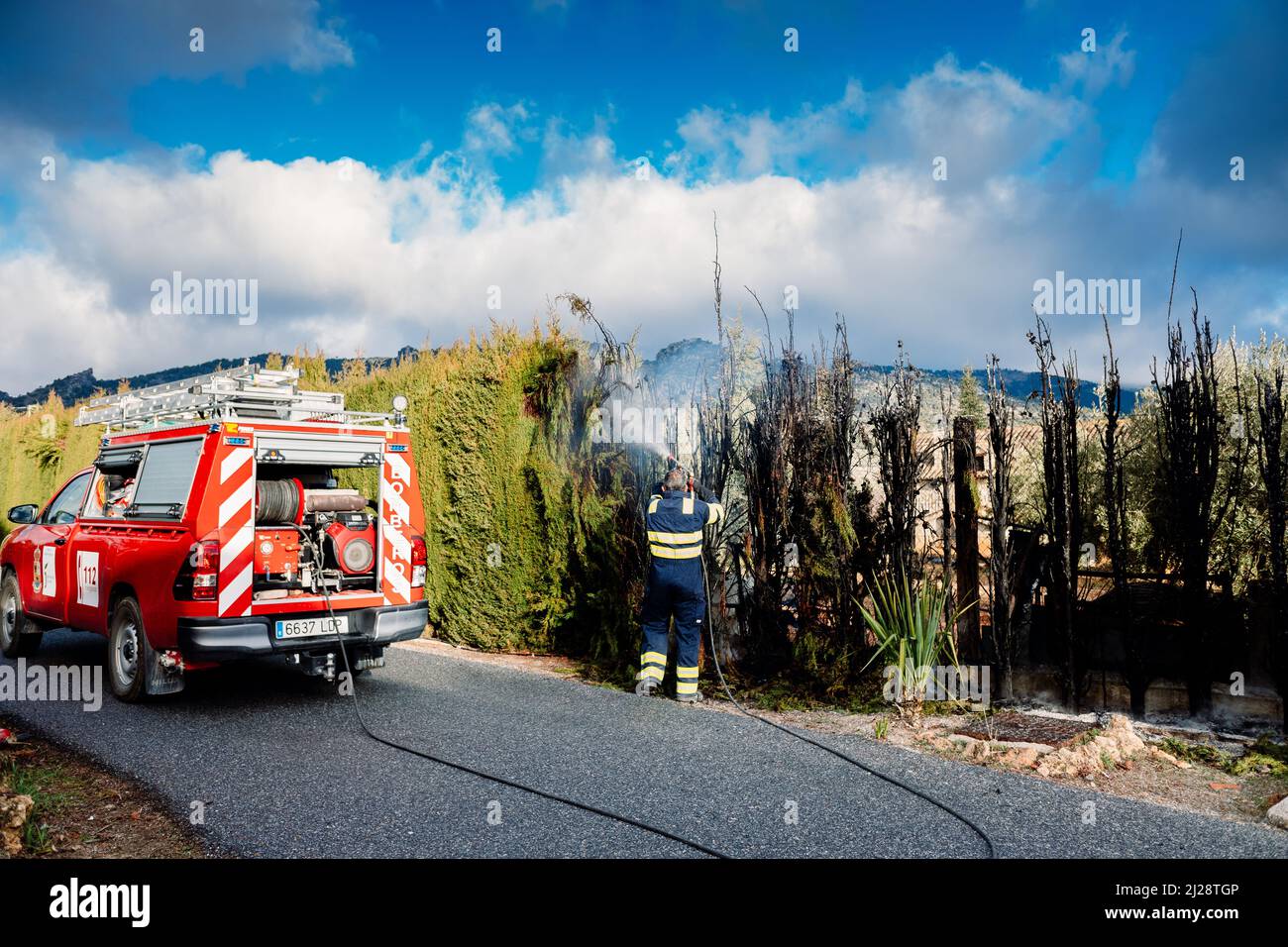 Jaén, Spain - March 13, 2022: A firefighter puts out a small fire in a ...
