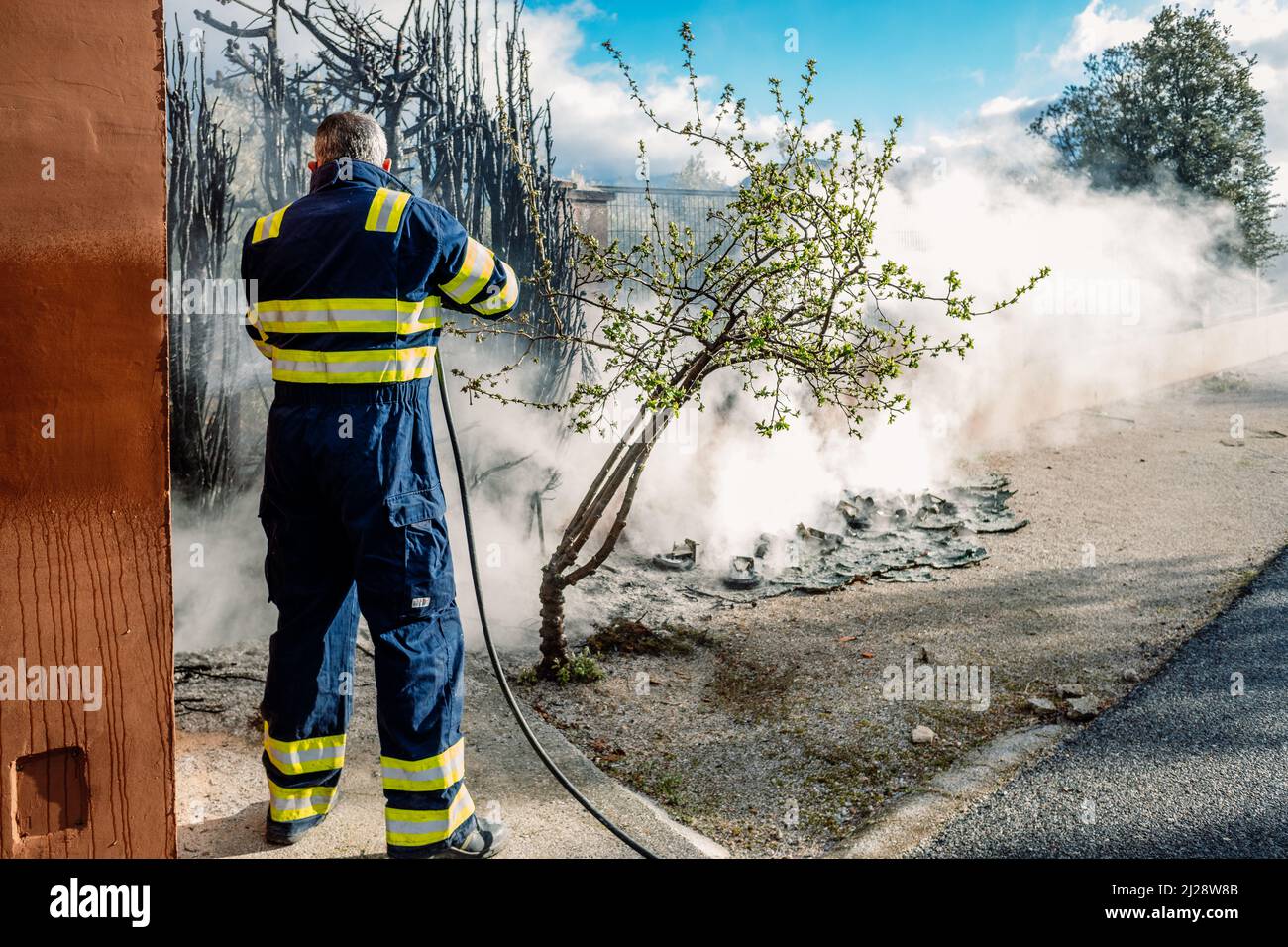 Firefighter extinguishes an outbreak of fire with water and causes a ...