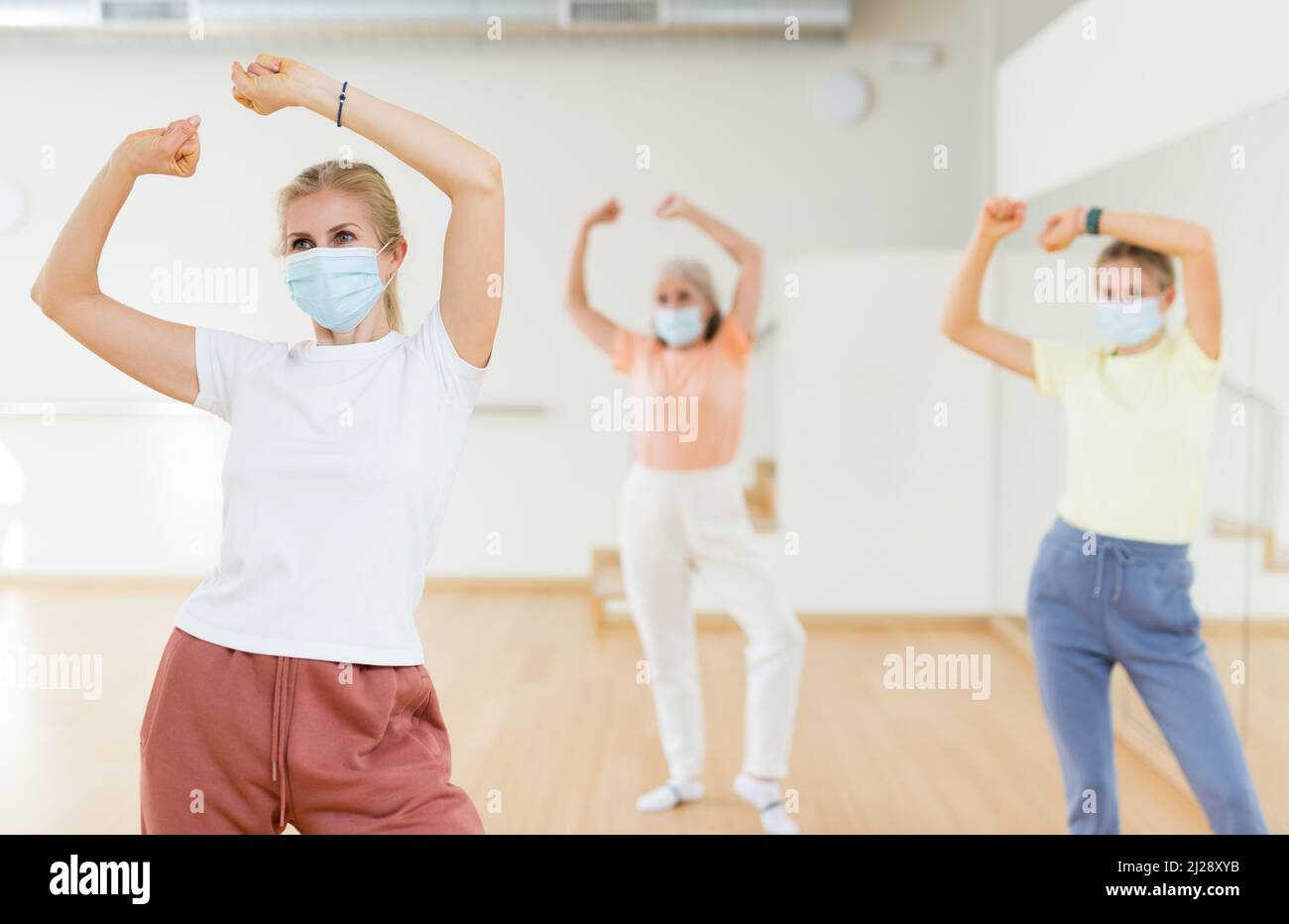Woman in mask dancing during group class Stock Photo - Alamy