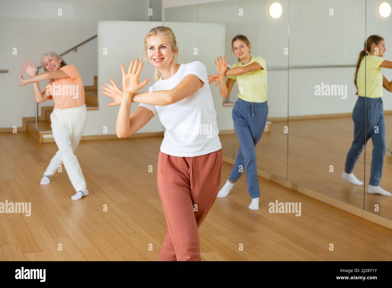 Woman learning aerobic dance with her family in studio Stock Photo - Alamy