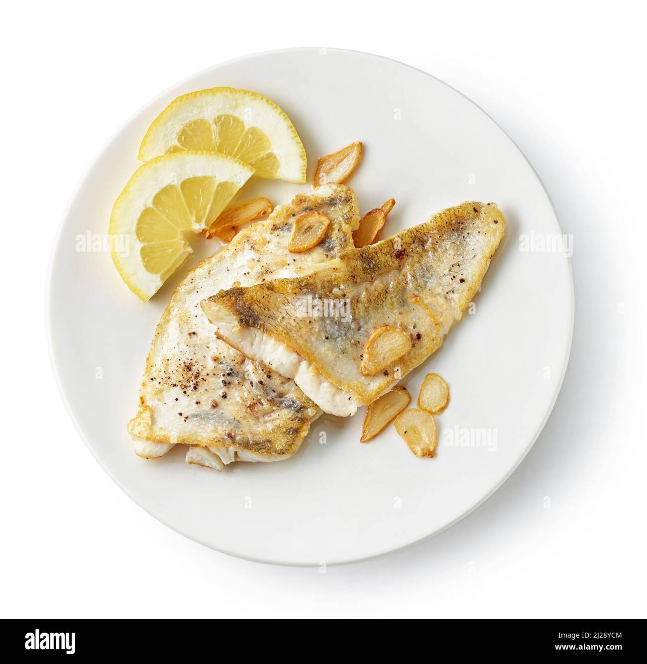 plate of roasted zander filet with garlic and lemon isolated on white ...