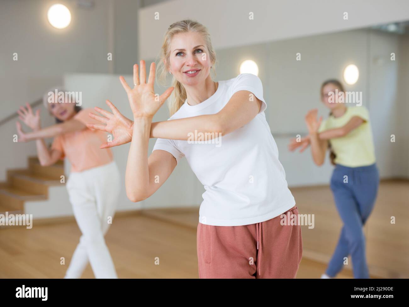 Woman performing aerobic dance during group training Stock Photo - Alamy