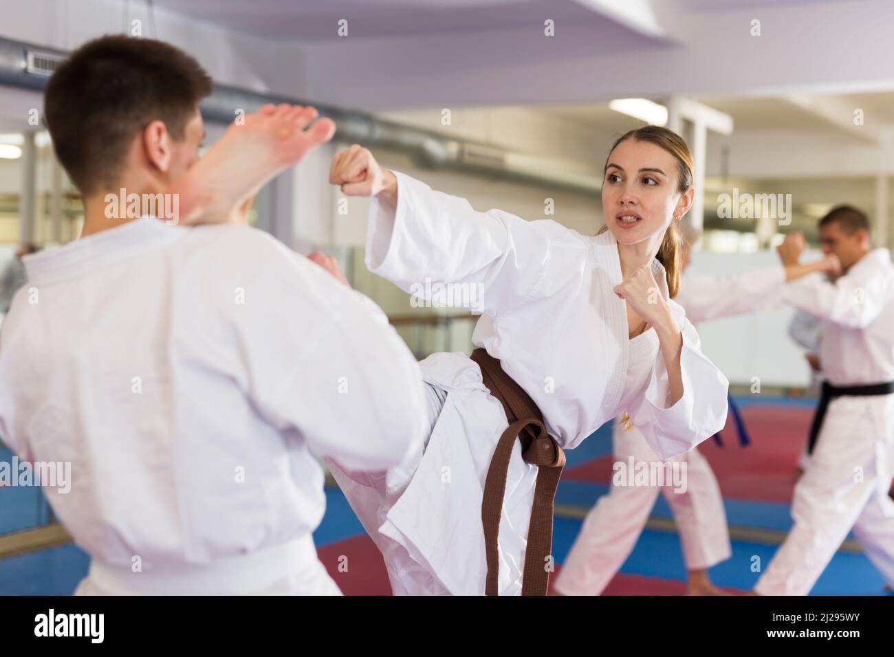 Woman sparring during group karate training Stock Photo - Alamy