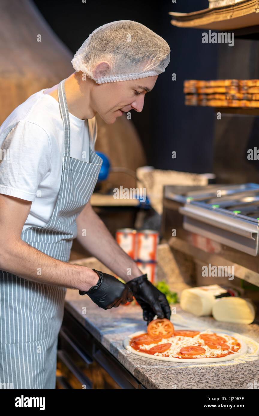 Italian chief-cooker baking pizza in the restaurant Stock Photo - Alamy