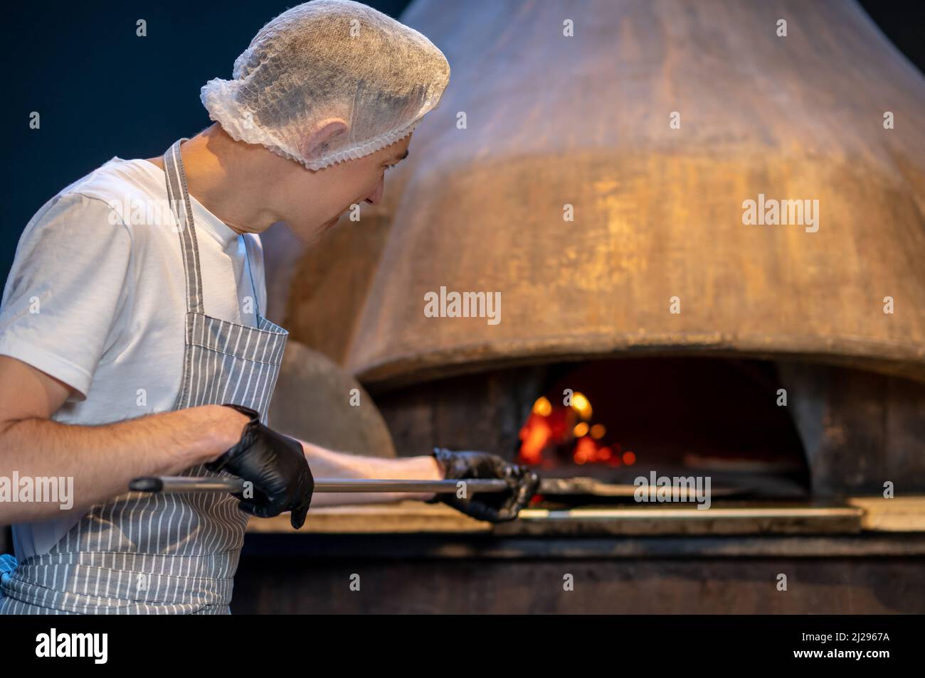 Italian chief-cooker baking pizza in the restaurant Stock Photo - Alamy