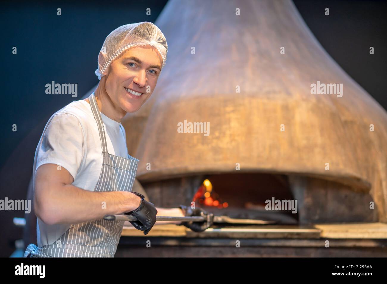 Italian chief-cooker baking pizza in the restaurant Stock Photo - Alamy