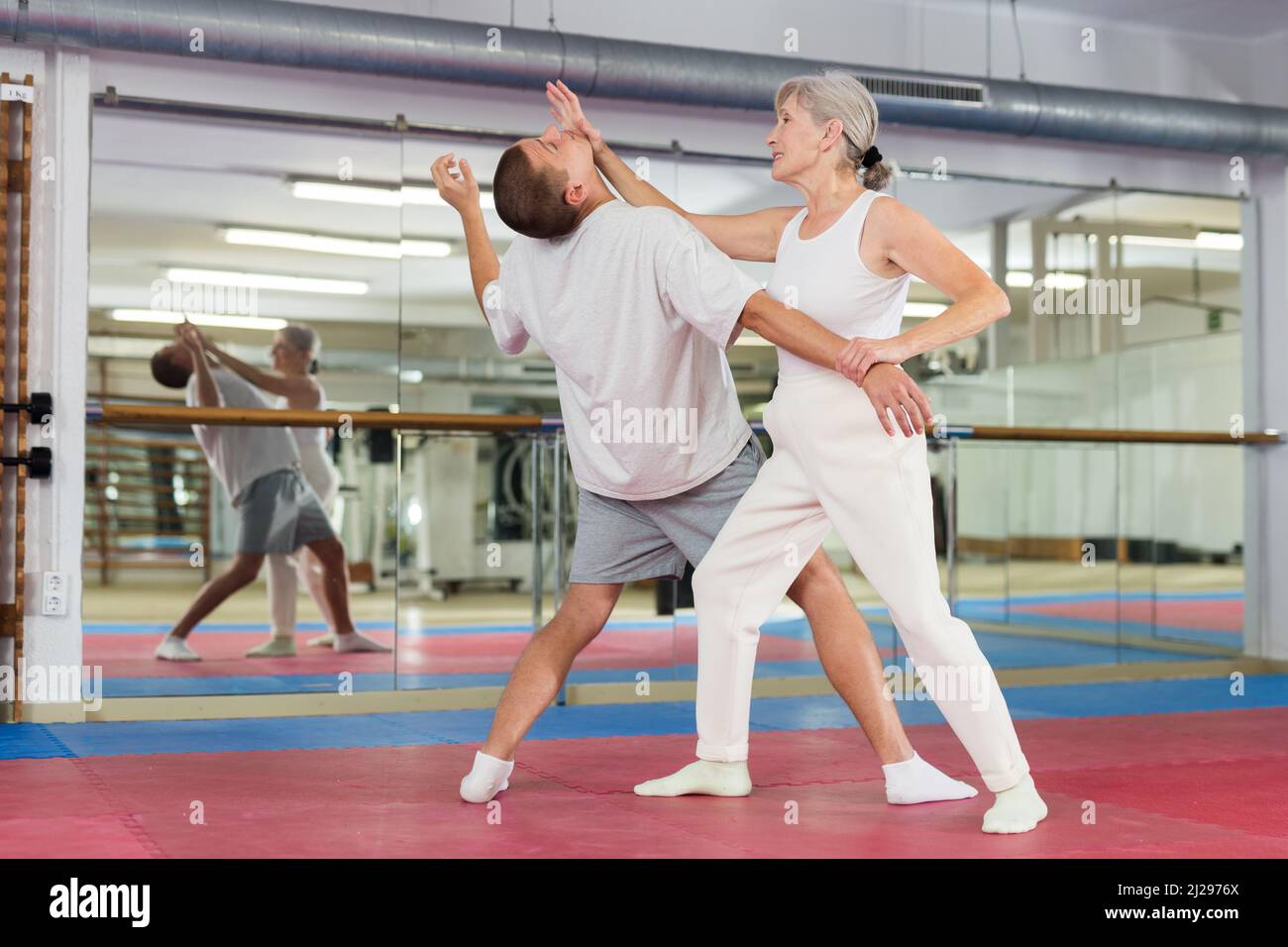 Senior woman performing chin strike during self-defence training Stock ...