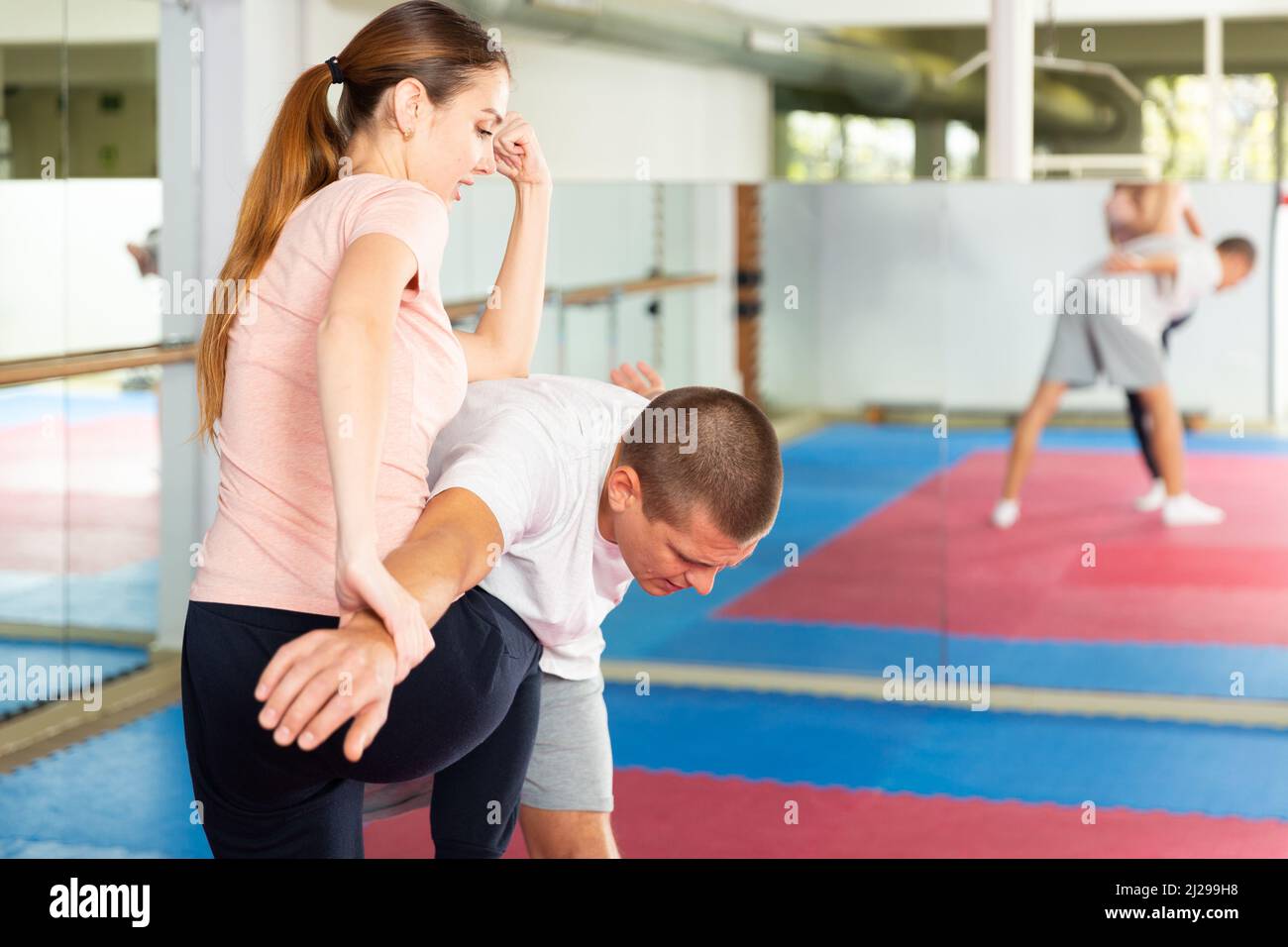 Young woman exercising knee strike during self-protection training ...