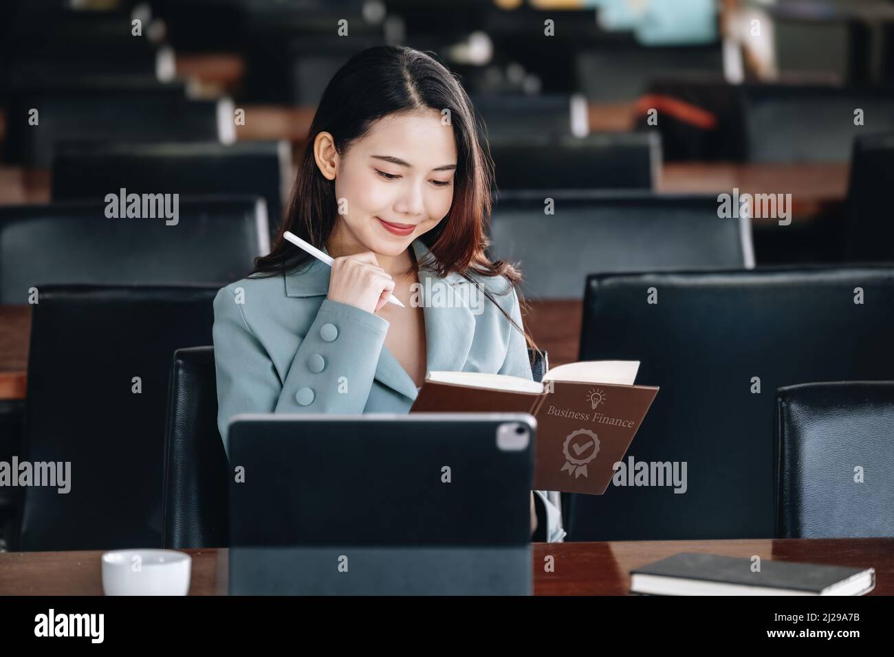 Asia woman entrepreneur showing a smiling face while reading a book ...