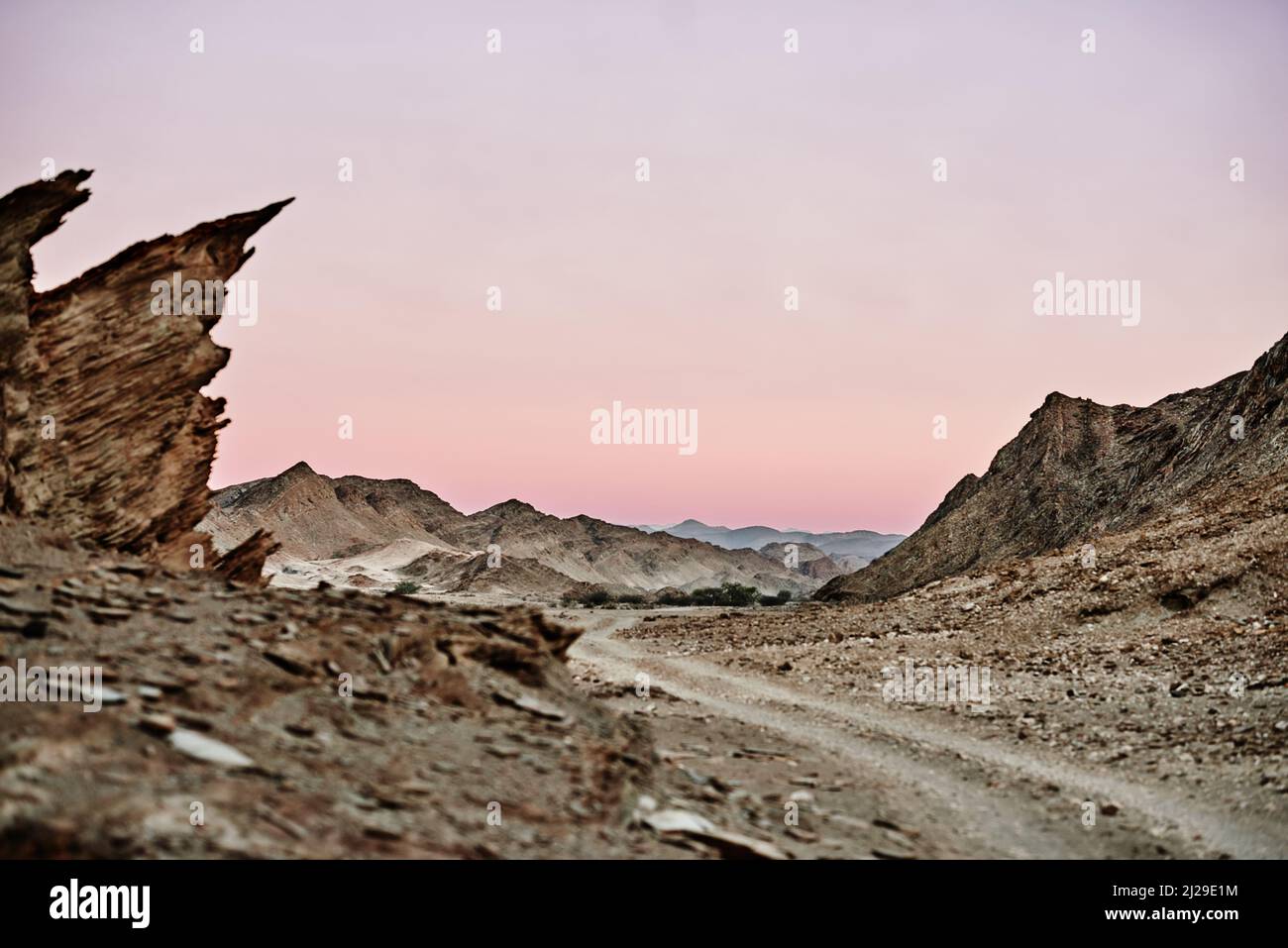 Through an otherworldly landscape. Shot of a dirt road running through ...