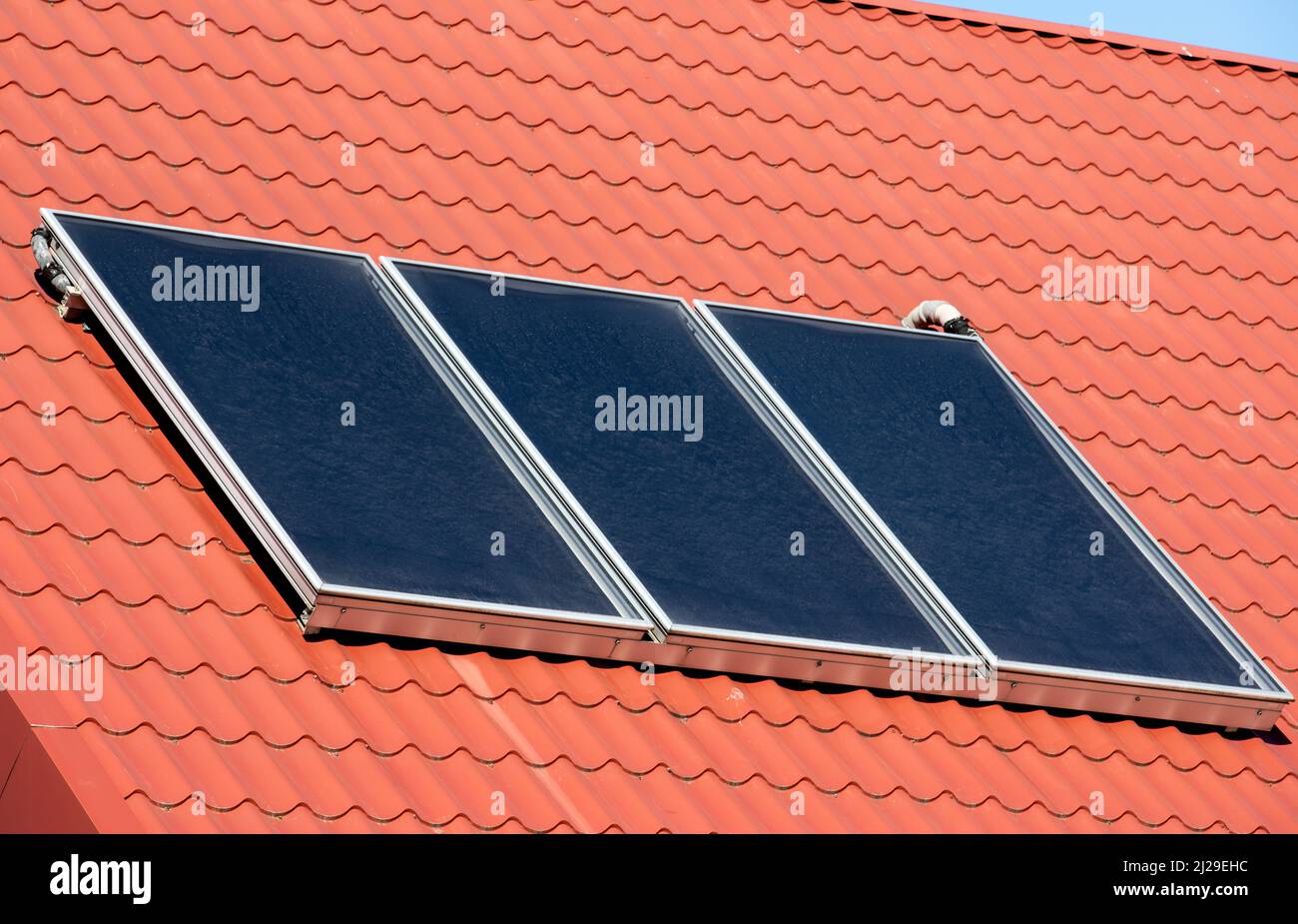 Water solar collector on a red metal roof Stock Photo - Alamy