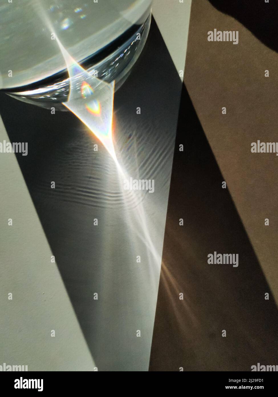 A vertical shot of a glass of water with reflection of light on the ...