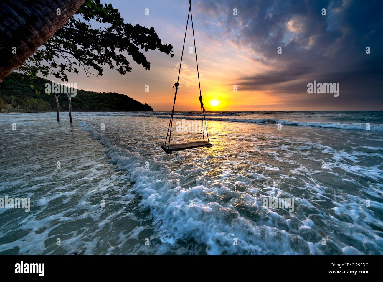 Tropical beach sunrise landscape with ocean waves and beach swings or ...