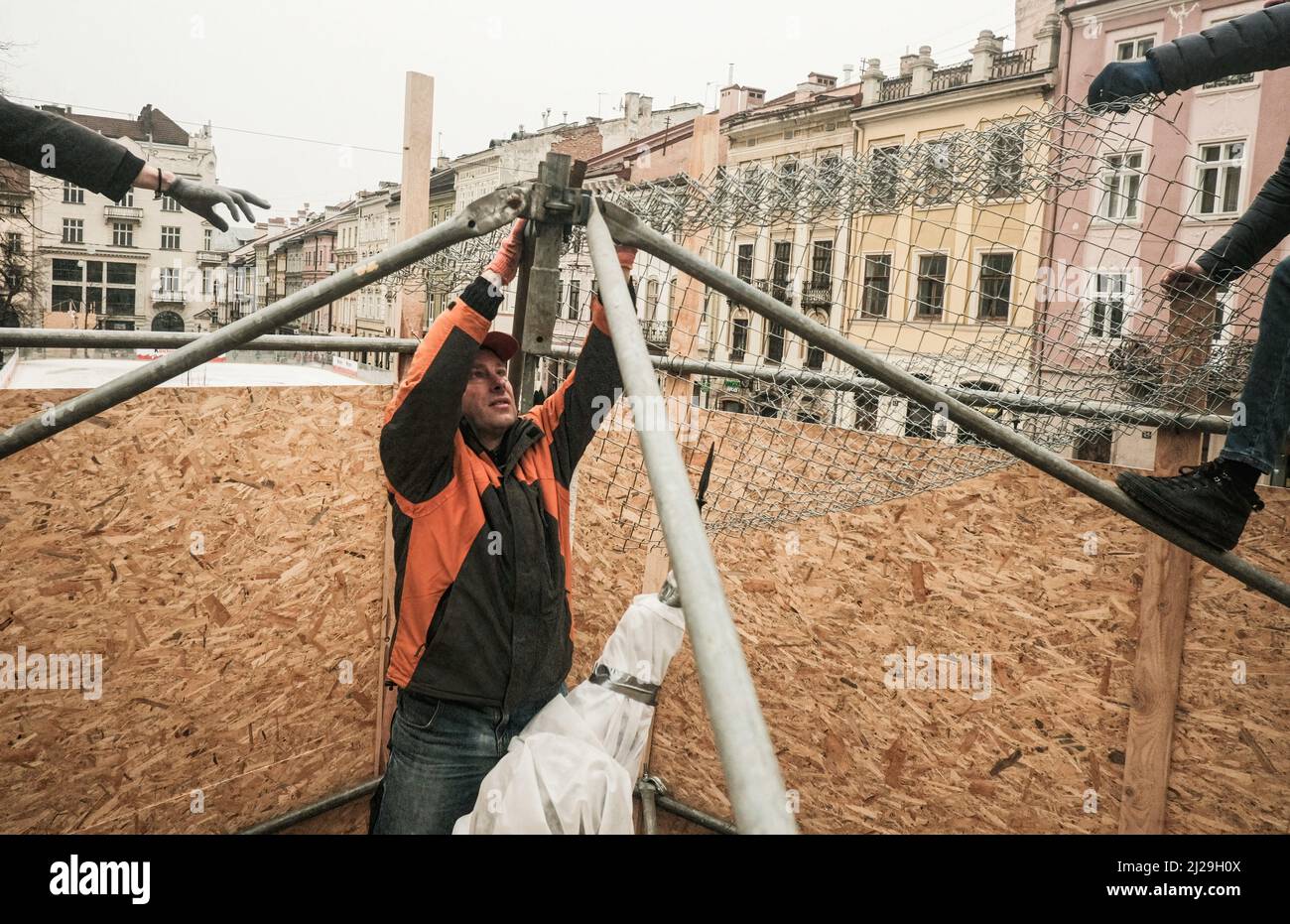 Kyiv, Ukraine. 16th Mar, 2022. Volunteers place wire fencing over a ...