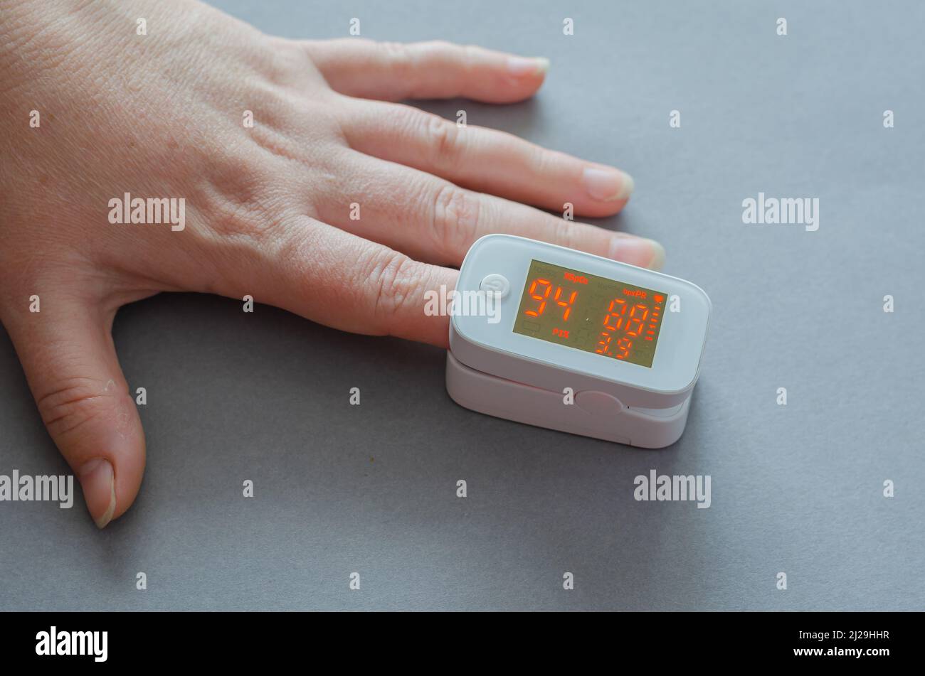 The oximeter is worn on the index finger of a woman's hand. A device ...