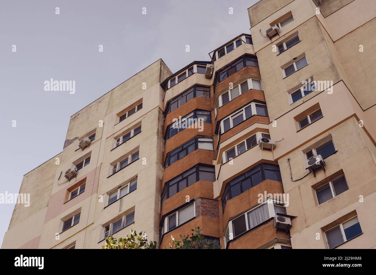 A beige building with brown balconies against the sky. High apartments ...