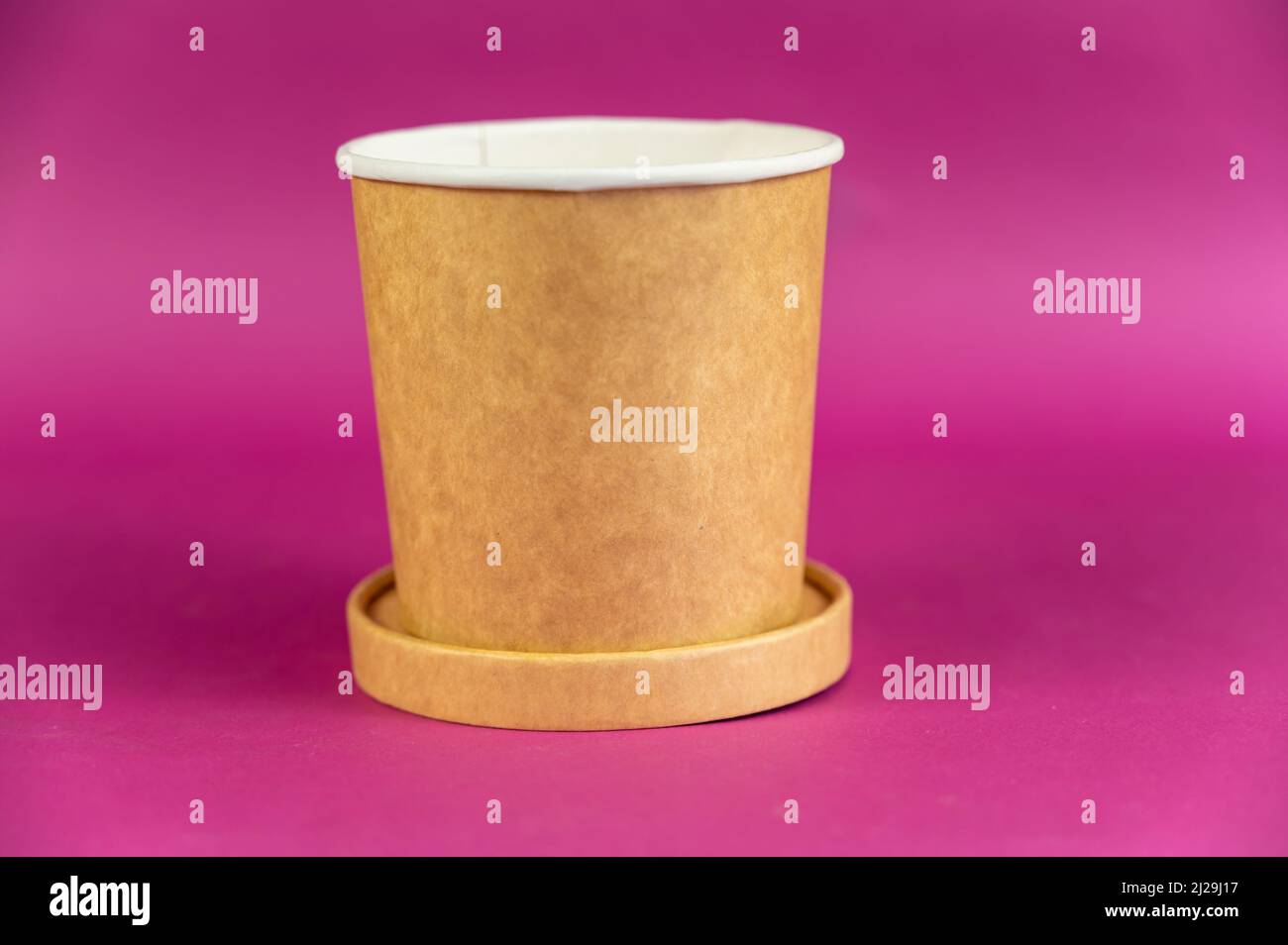 Empty cylindrical paper container with lid opposite-colored background ...