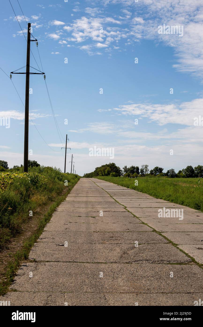Rural landscape with concrete road and power line Stock Photo - Alamy