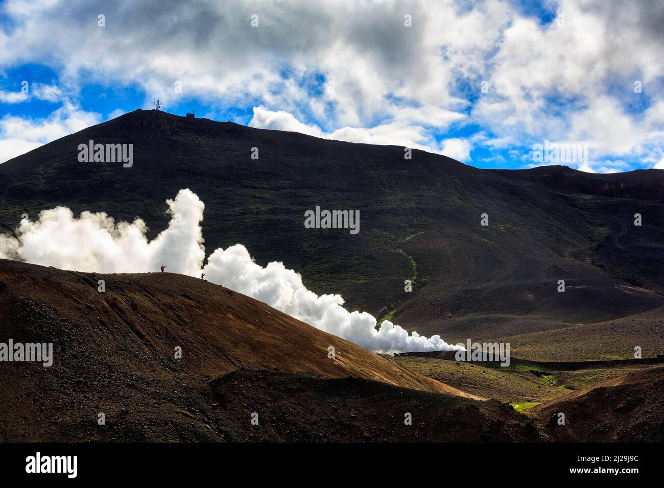 Hikers on the crater rim in summer, steam, geothermal energy at crater ...