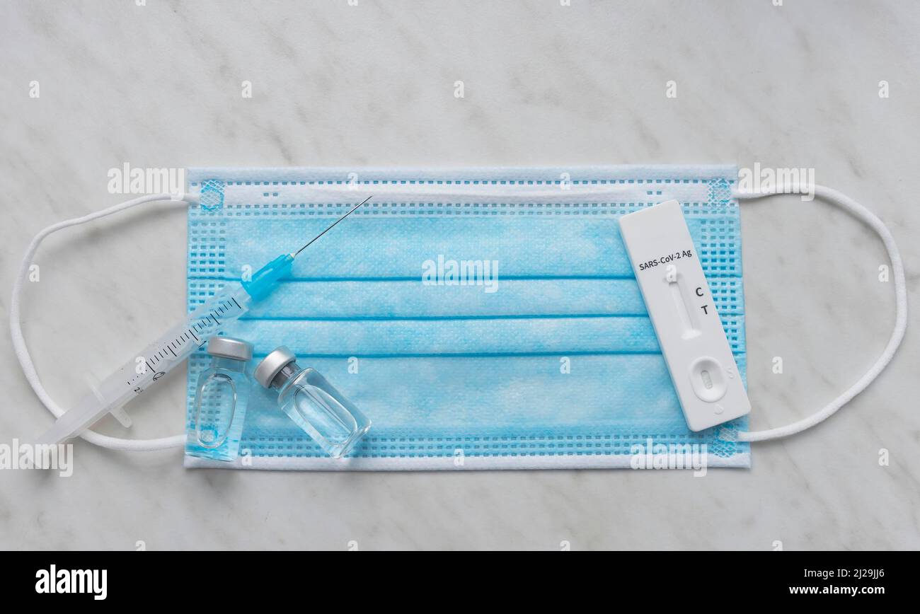 Medical mask, antigen test, vaccine bottles and syringe used for ...