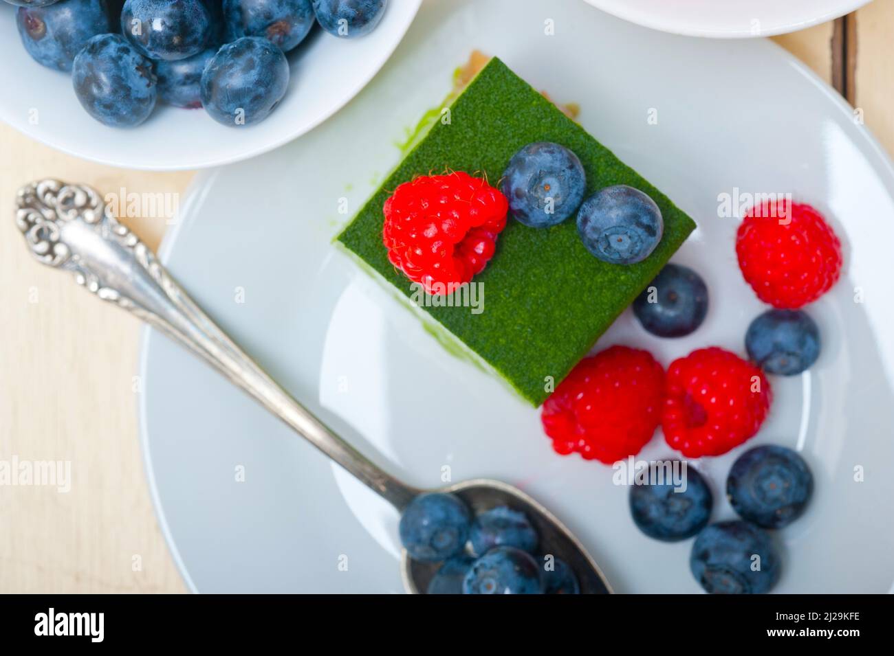Green tea matcha mousse cake with raspberries and blueberries on top ...